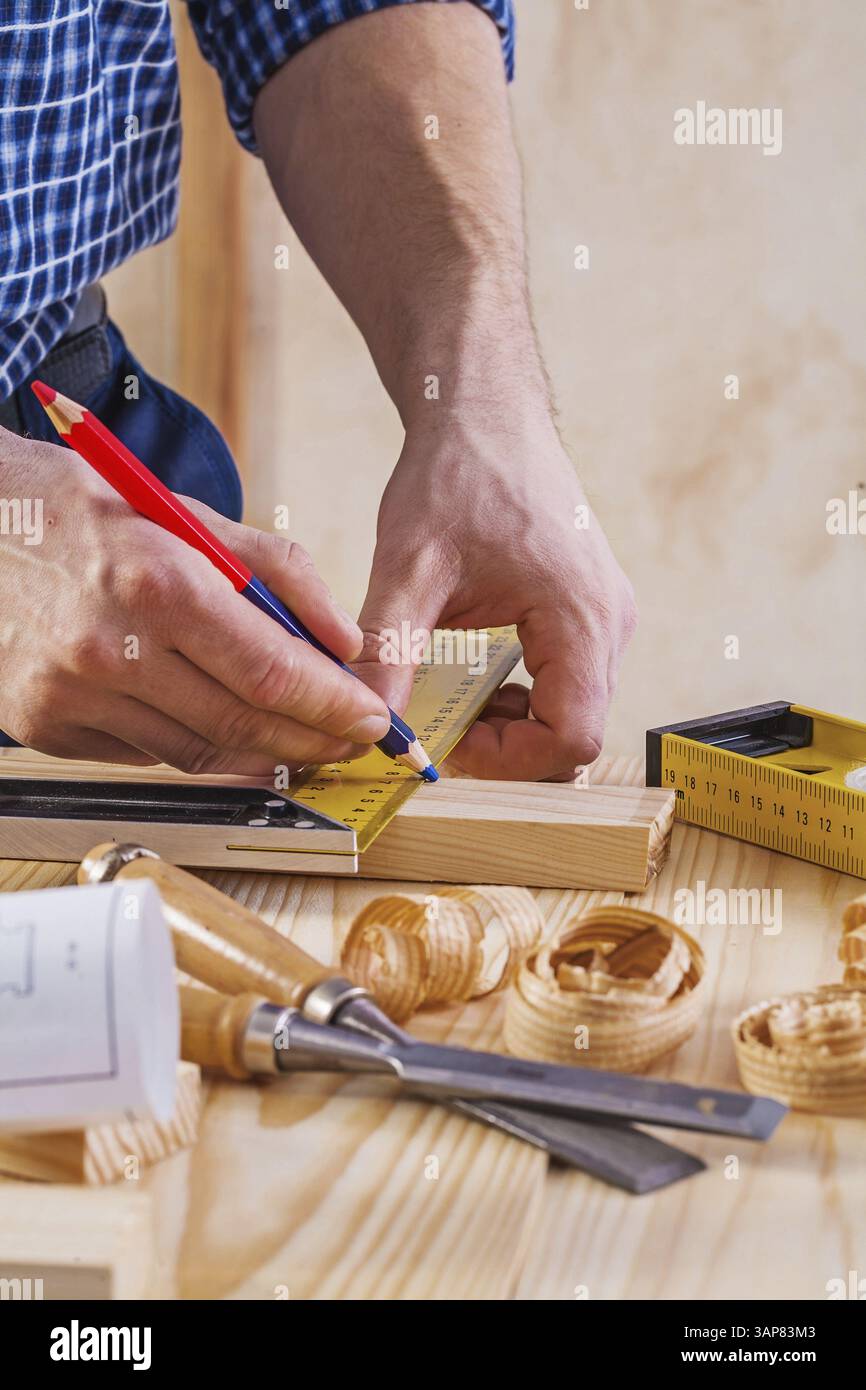 Hands of carpenter drawing with pencil on wooden planks construction ...