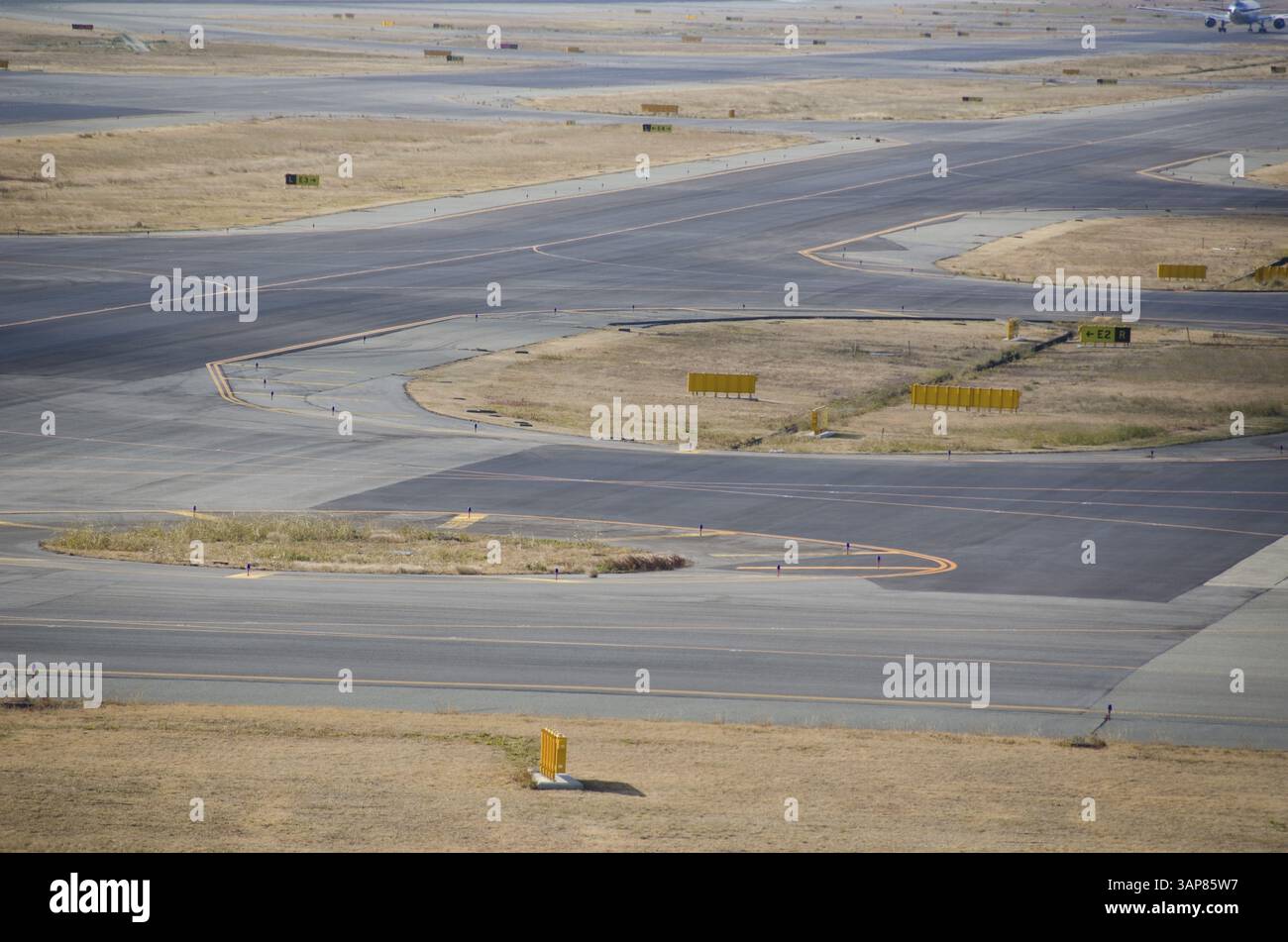 Detail of a runway at a airport with asphalt and grass Stock Photo - Alamy