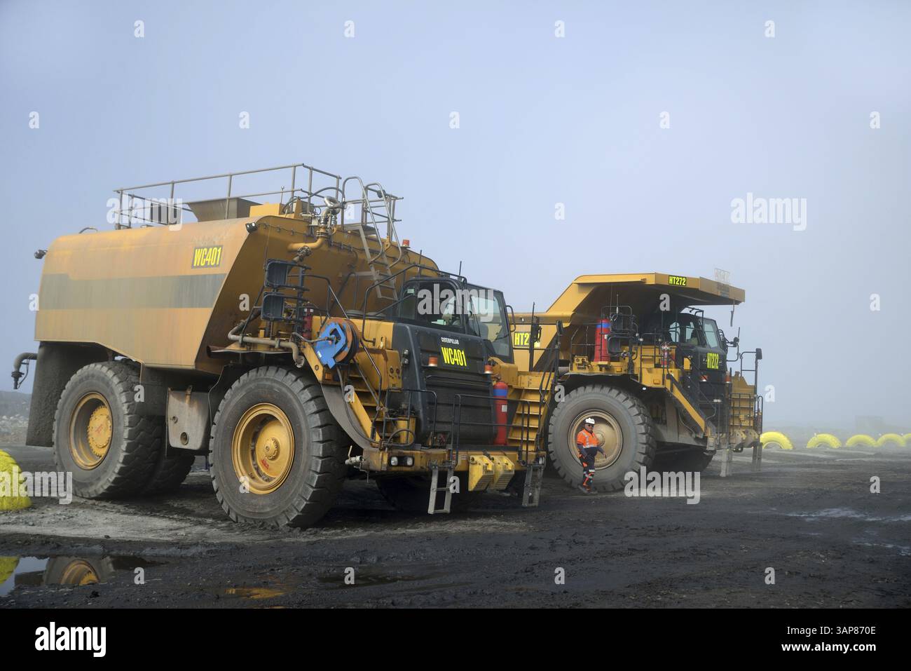 A driver walks out from between a water tanker and a 130 ton tiptruck ...