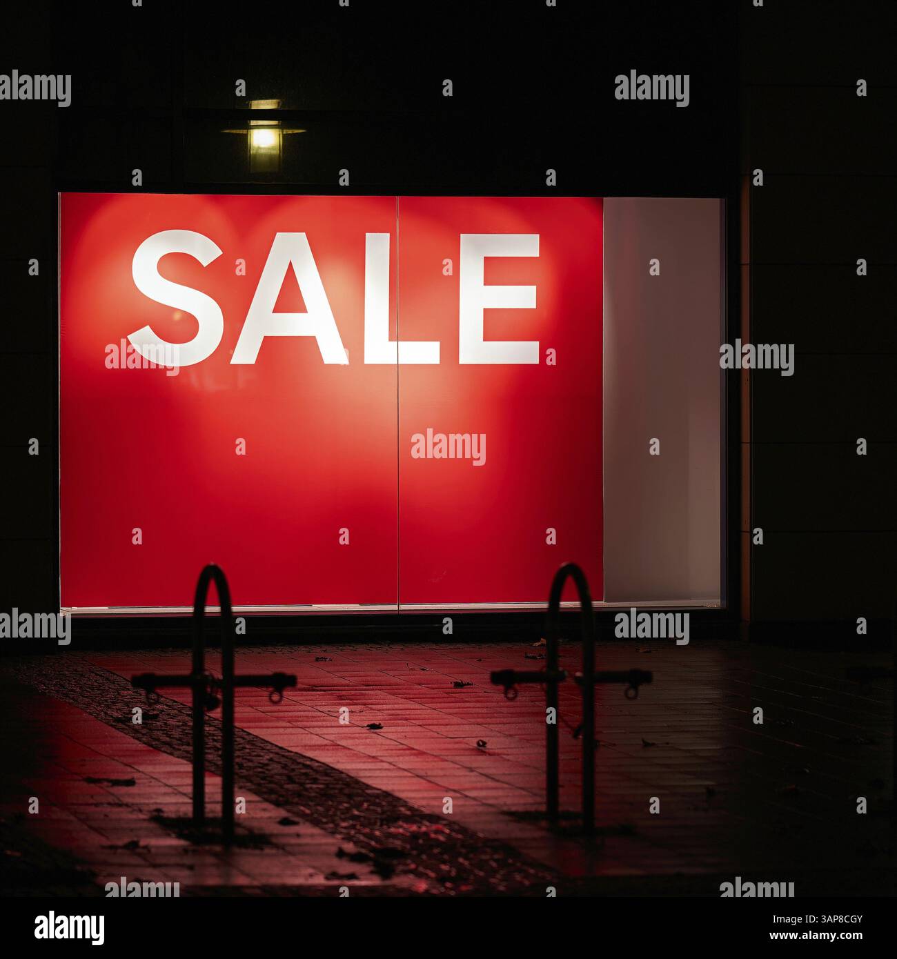 Illuminated red shop window with Sale lettering Stock Photo - Alamy
