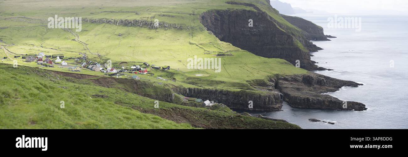 Panorama of the village Mykines on the Faroe Islands with cliff blue ...