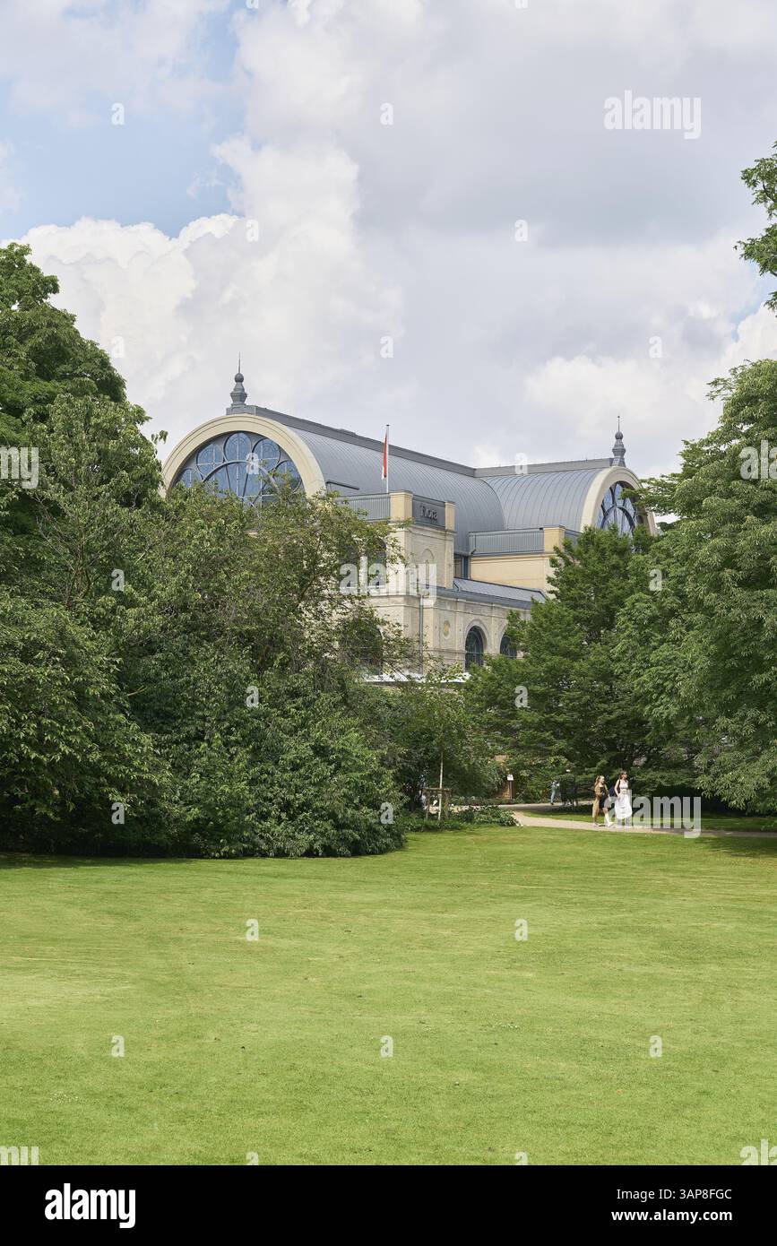 View across a meadow to the Flora building, the botanical garden in ...