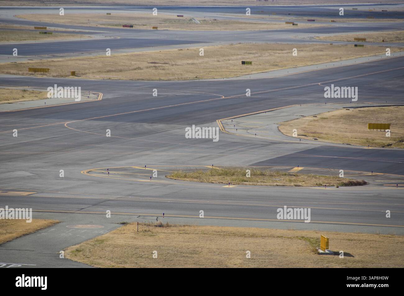 Detail of a runway at a airport with asphalt and grass Stock Photo - Alamy