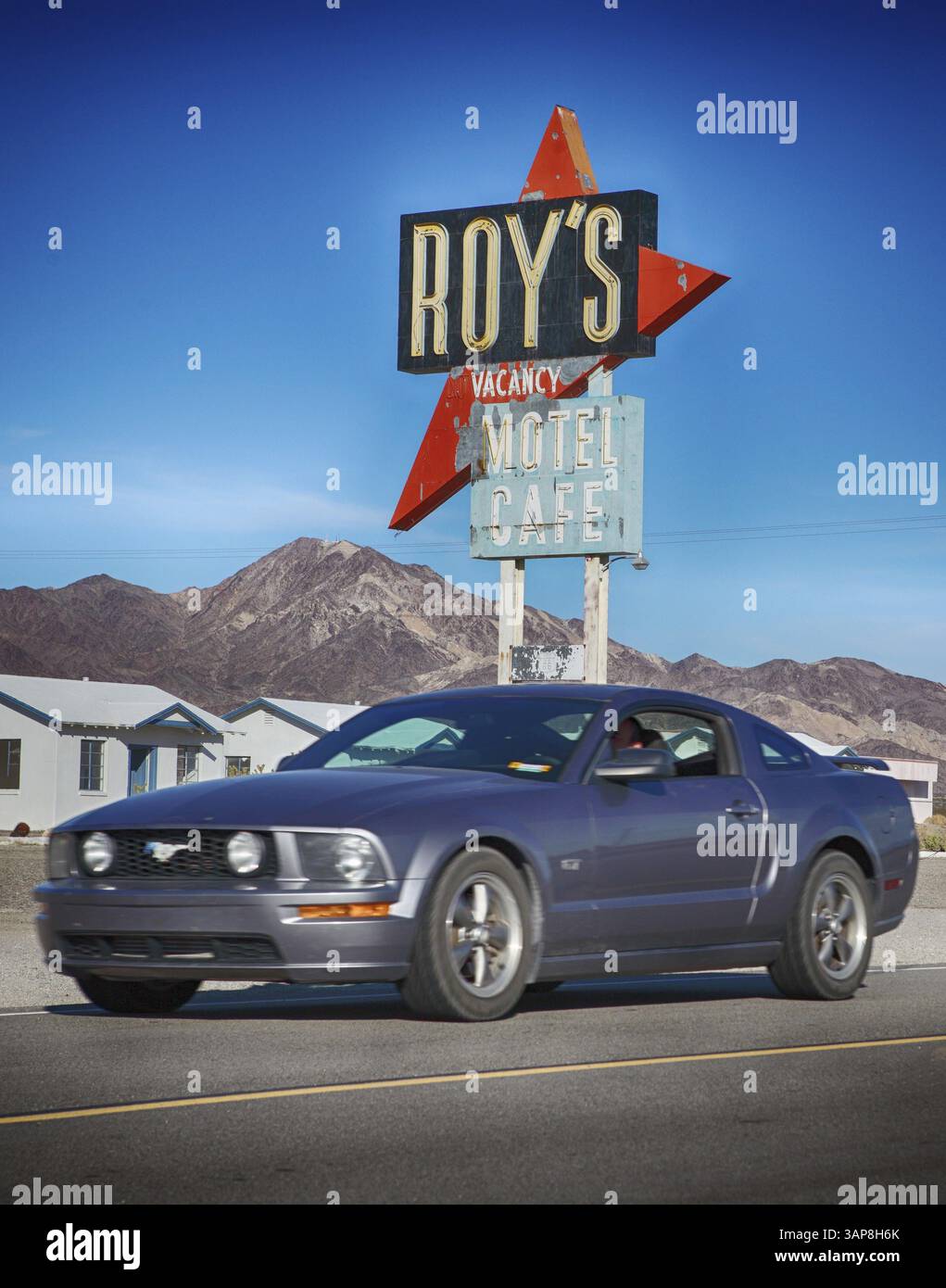 A Mustang drives past the Roy's Motel sign on Route 66 in California ...