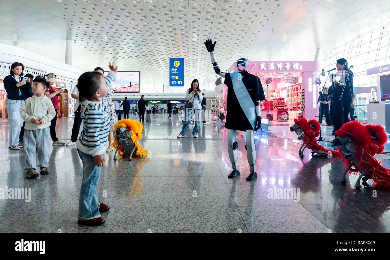 Wuhan,China.15th April 2025. A child interacts with at an Unitree G1 ...