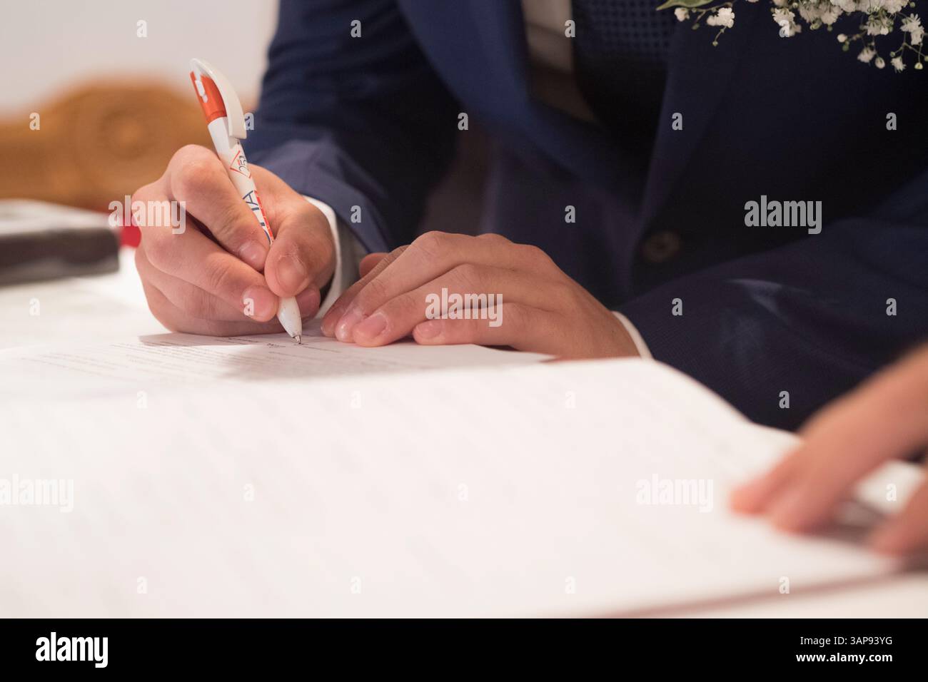 A close-up shows the groom's hand signing the wedding register in Italy ...