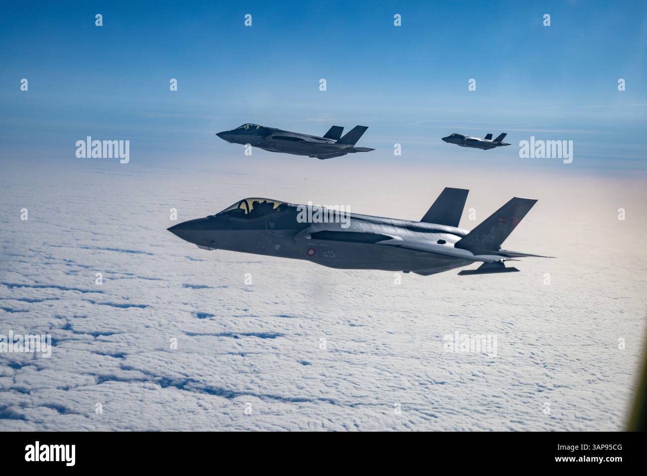 Three Royal Danish Air Force F-35 Lightning IIs fly alongside a U.S ...