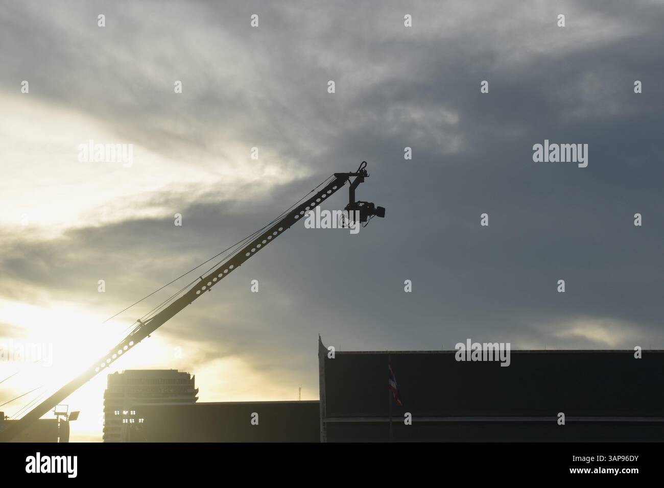 video camera hanging on heavy crane for shooting top view in sunset sky ...