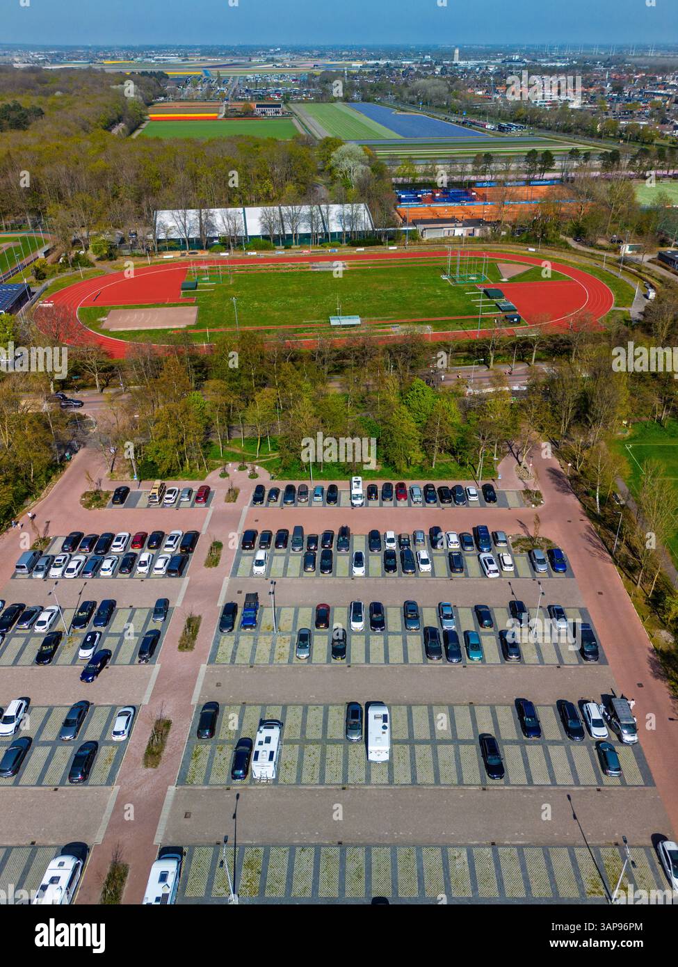 Aerial view of a sports complex with a red running track, green field ...