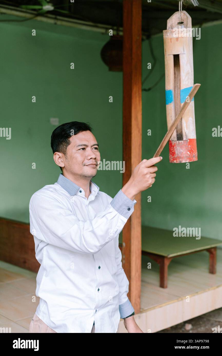 An Indonesian man demonstrates how to play a traditional bamboo musical ...