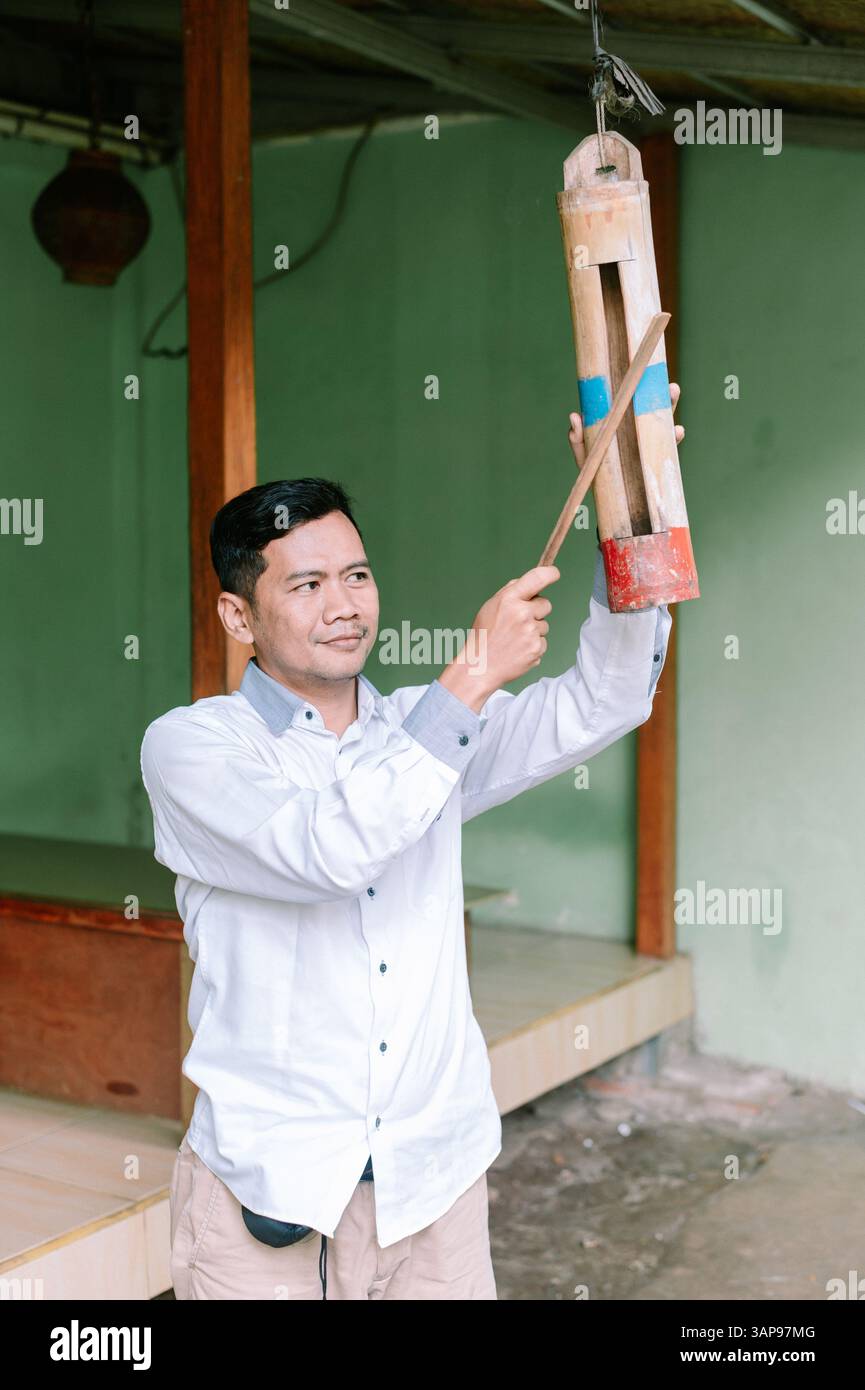 Man in white shirt showing how to play a Kulintang instrument, a ...