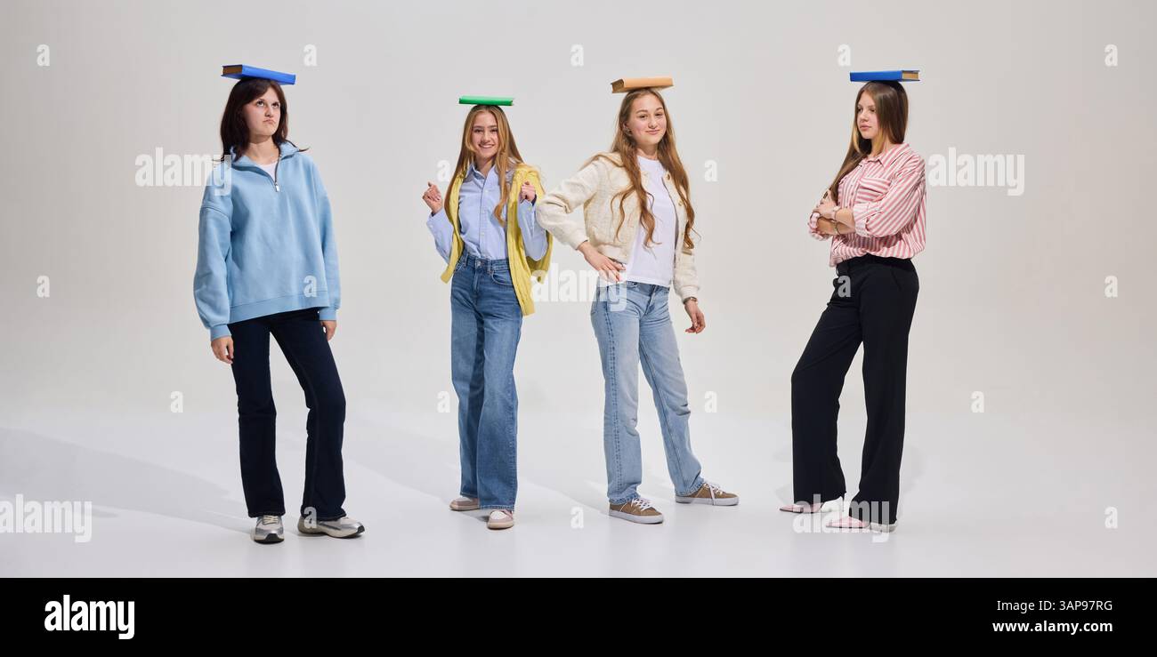 Four students stand in line with books on heads, expressing different ...