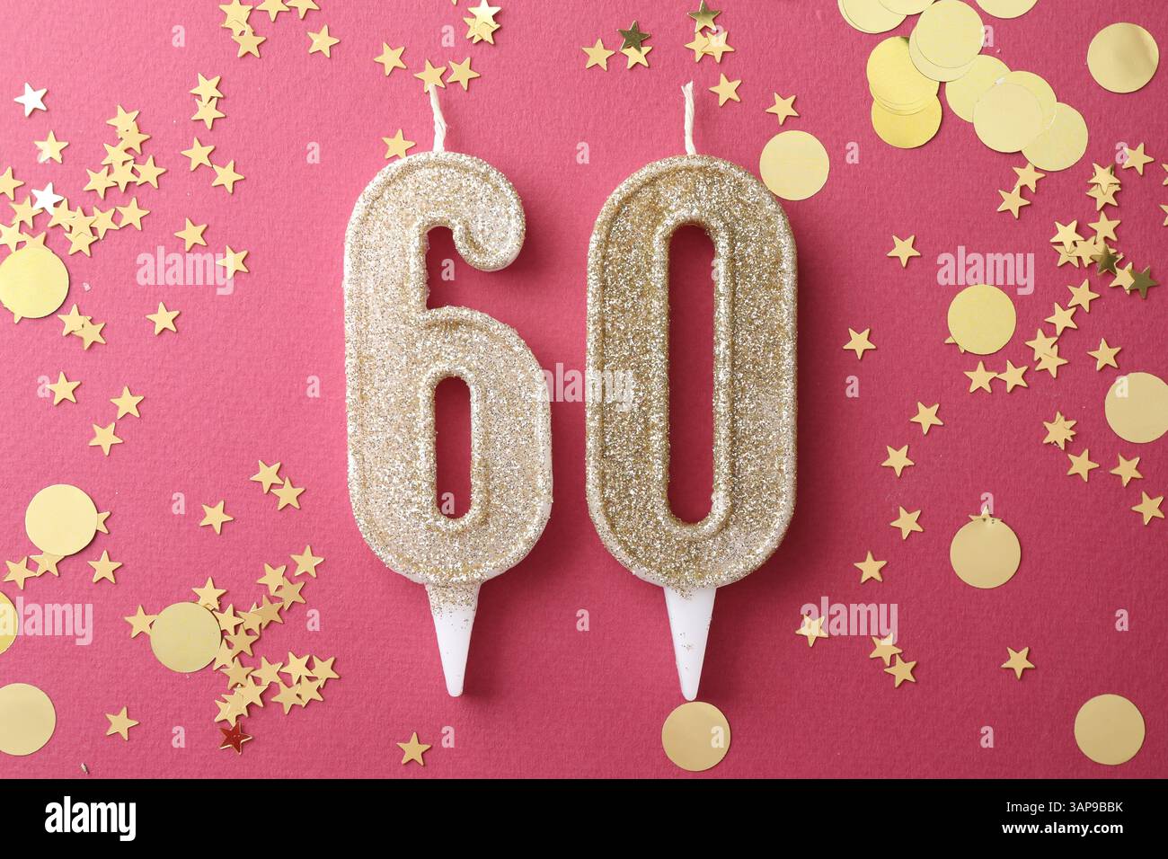 60th birthday. Number shaped candles and confetti on pink background ...