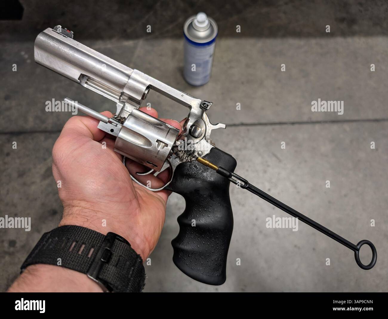 A man's hand holds a silver revolver with the cylinder open during the ...
