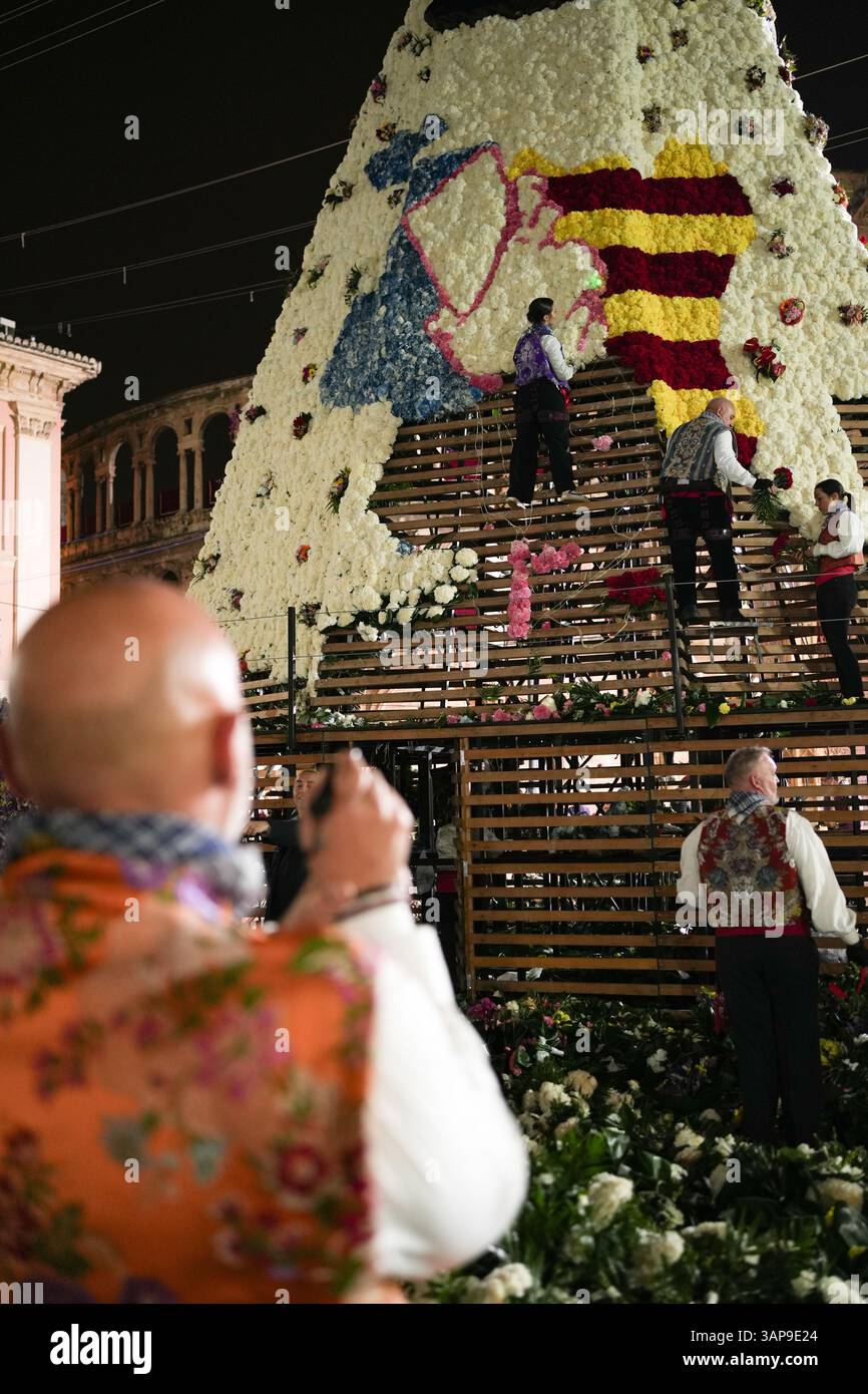 Men in traditional costume climbed on a giant wooden structure ...