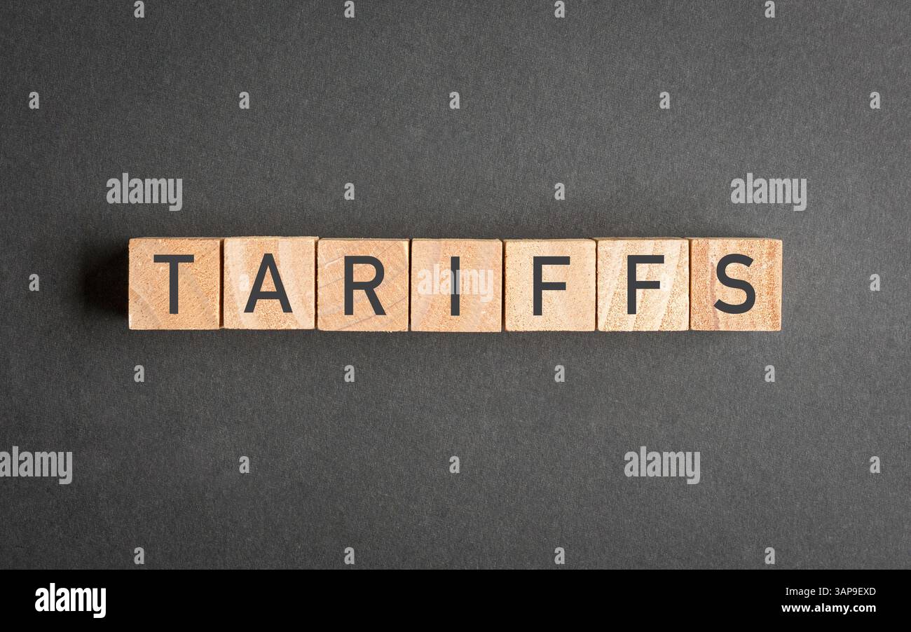 Tariffs, word on square wooden blocks. Against dark gray surface Stock ...