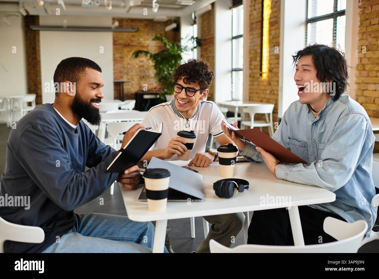 Three colleagues engage in lively discussion while enjoying coffee in a ...