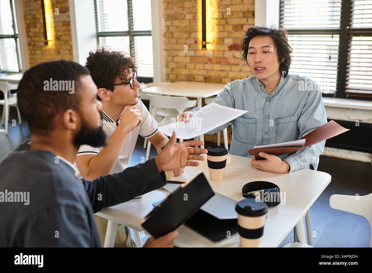 Three professionals engage in a lively discussion at work, sharing ...