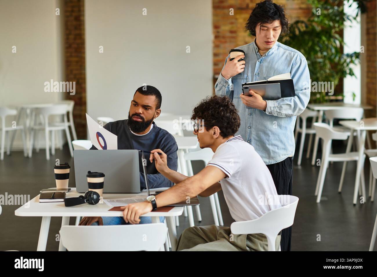 Team members actively collaborate around a table in a sleek office ...