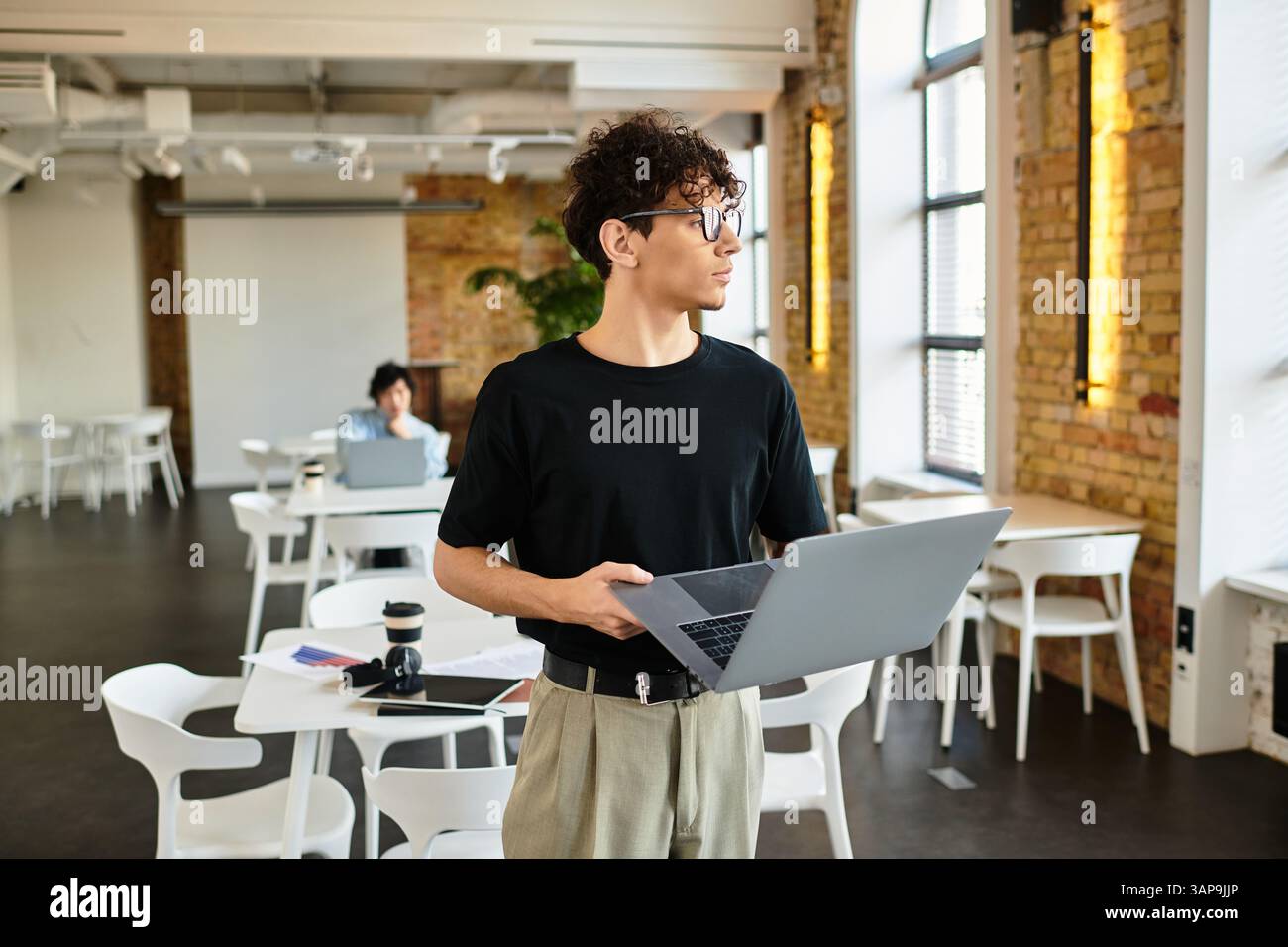 Individual exudes confidence with a laptop in a stylish, productive workspace Stock Photo - Alamy