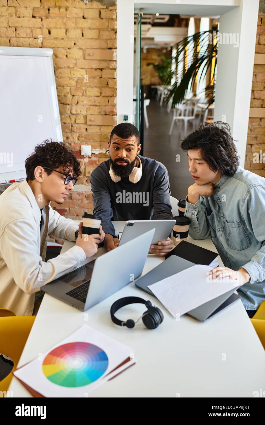 Three individuals engage in a dynamic discussion at a workspace while ...