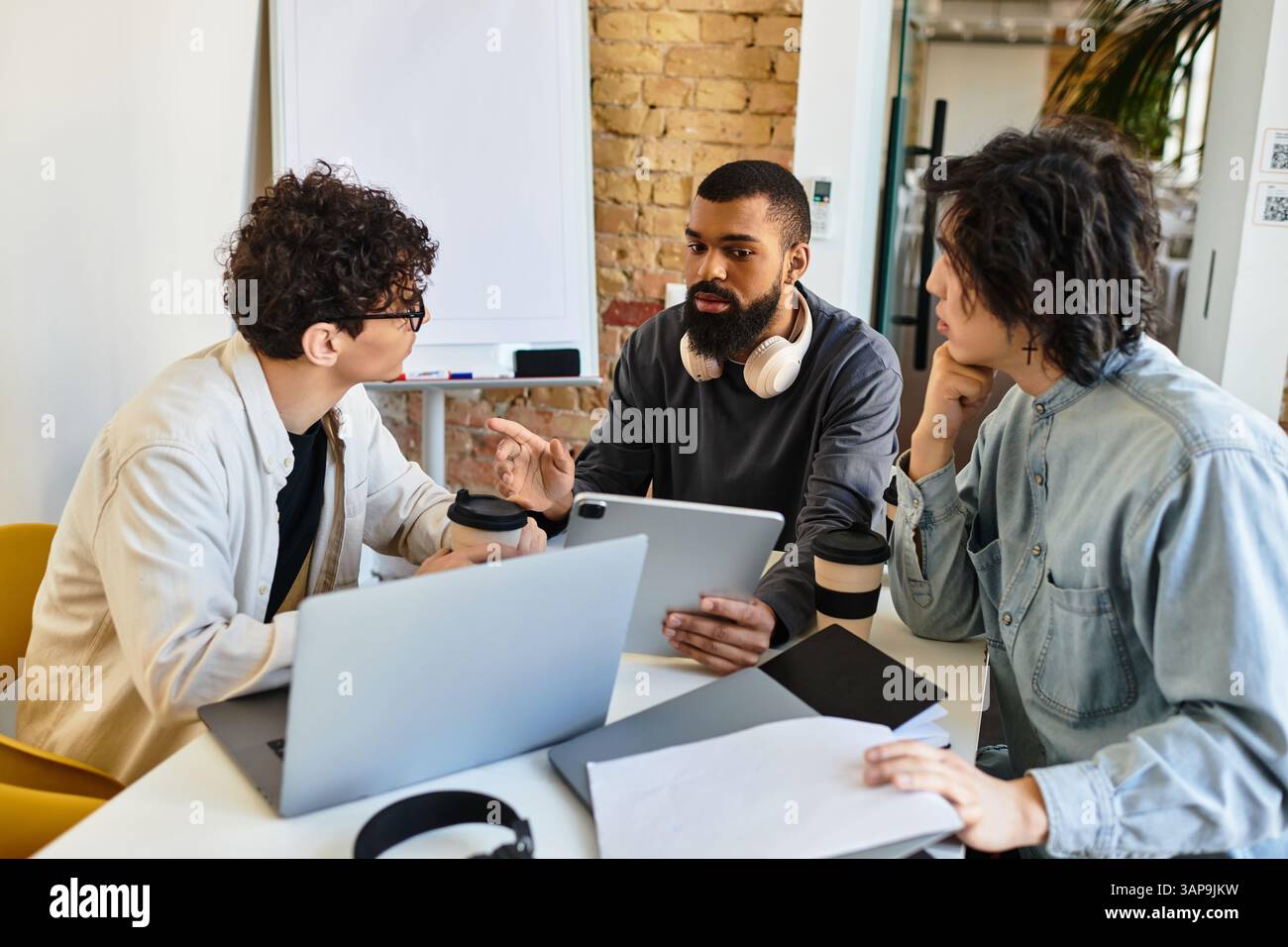 Three professionals discuss ideas in a collaborative workspace with ...