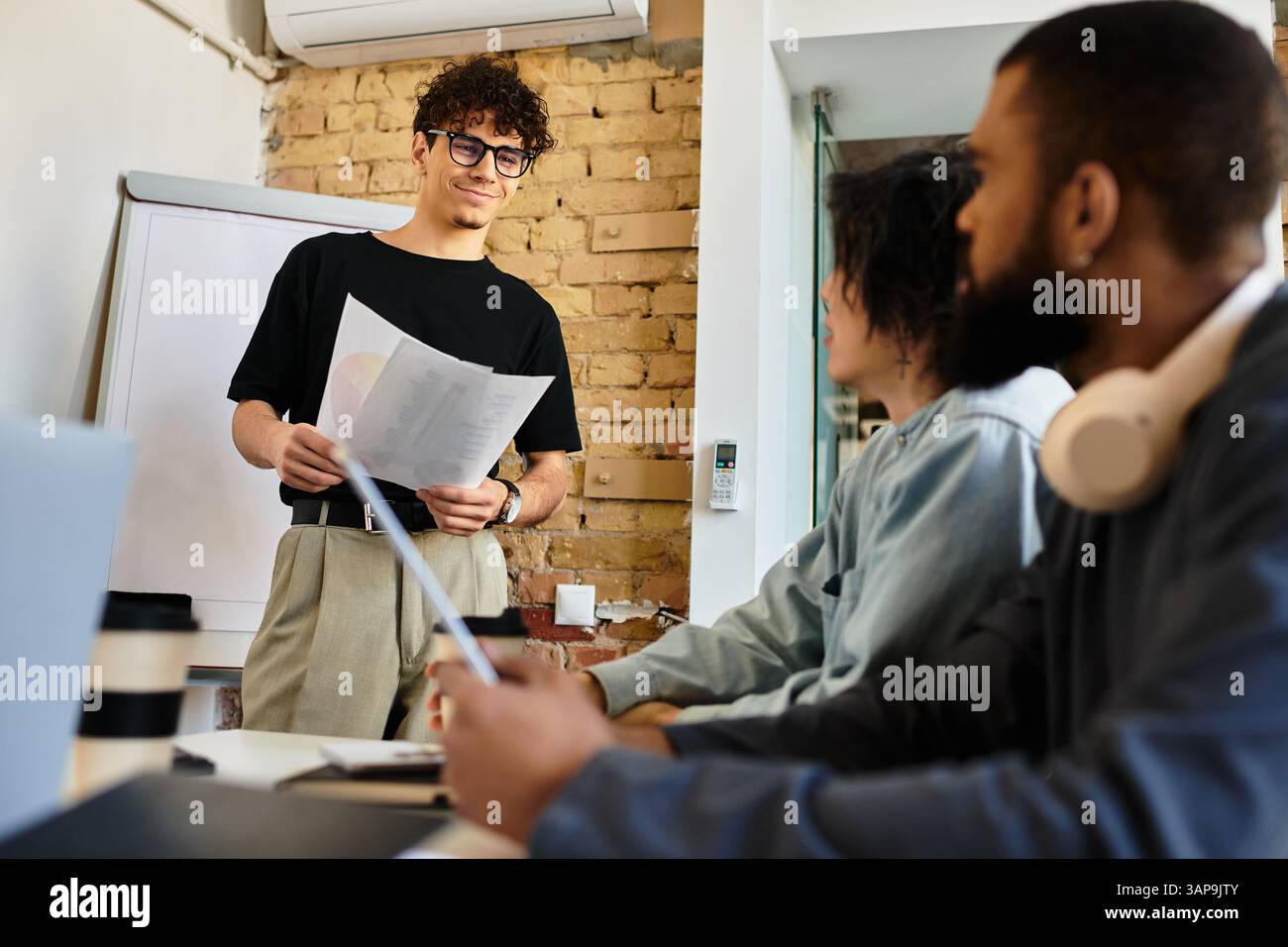 Team members gather around a table discussing innovative ideas while ...