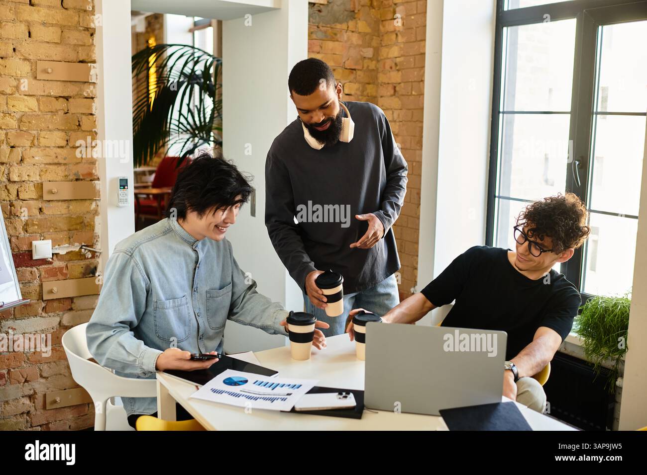 Three colleagues engage in a lively discussion, sharing ideas over ...
