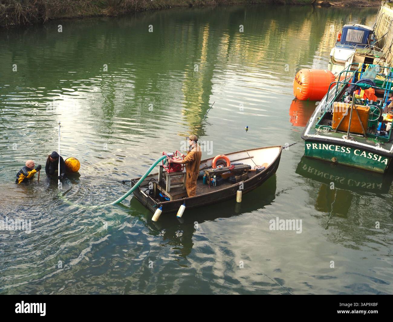 Divers use water pumped from support boat and manual tools to free ...