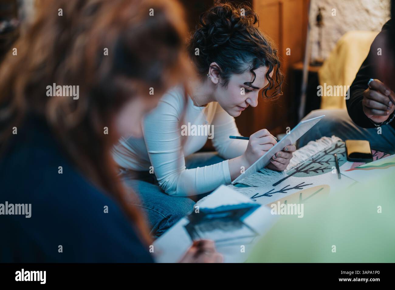 Creative individuals drawing sketches together in a casual indoor ...