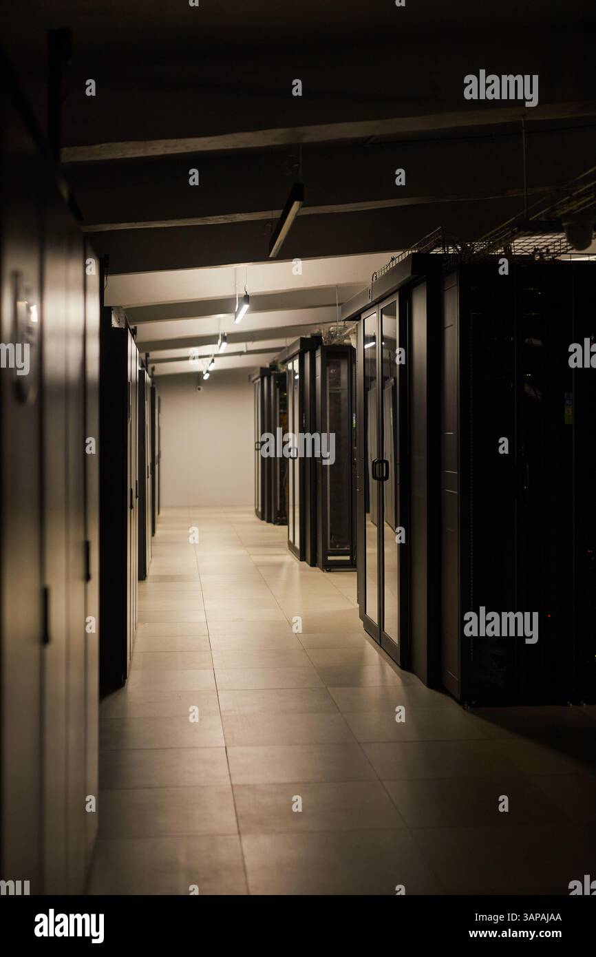 Spacious server room corridor illuminated by overhead lighting ...