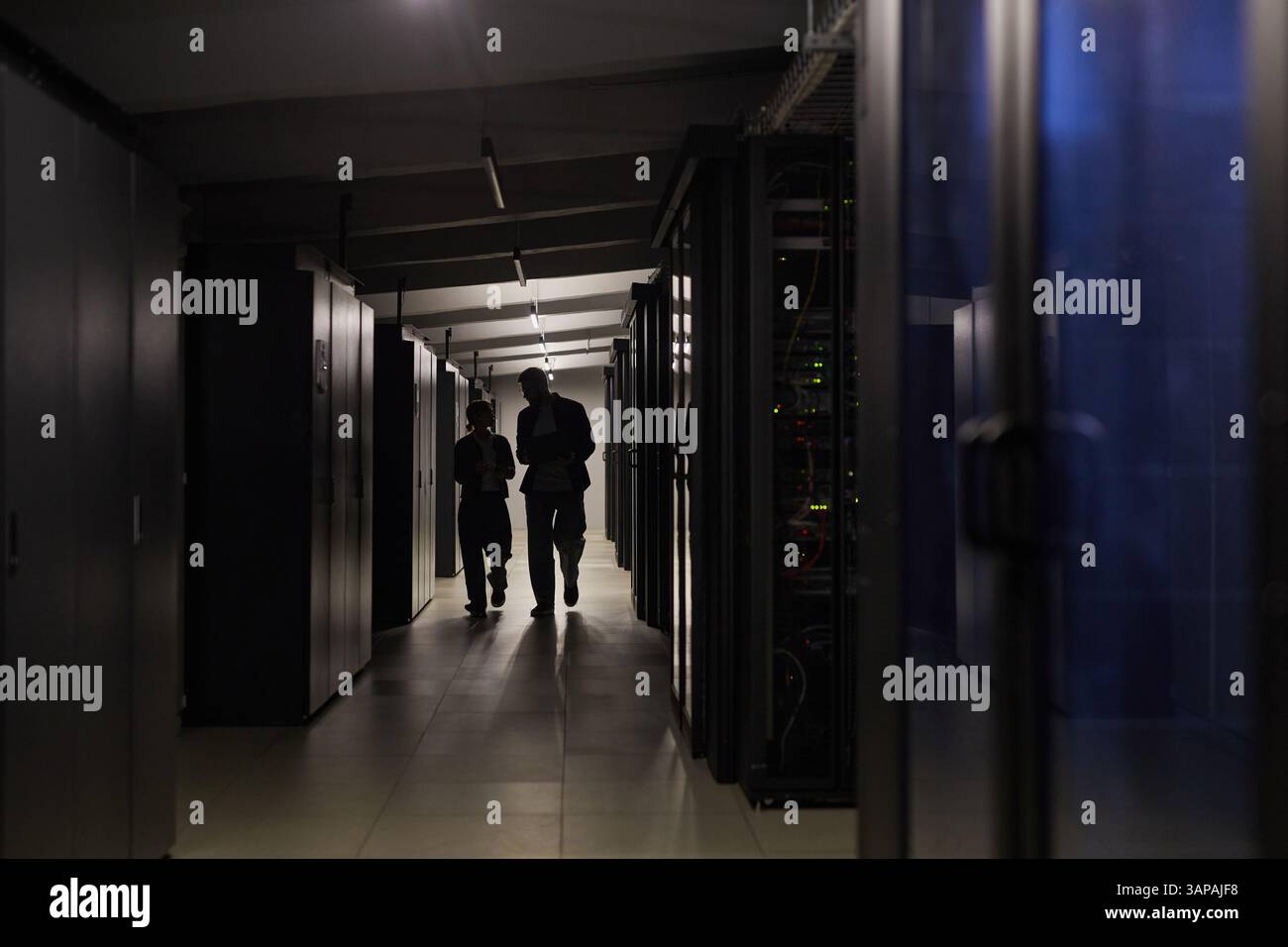Technicians silhouetted against the light while walking through a ...