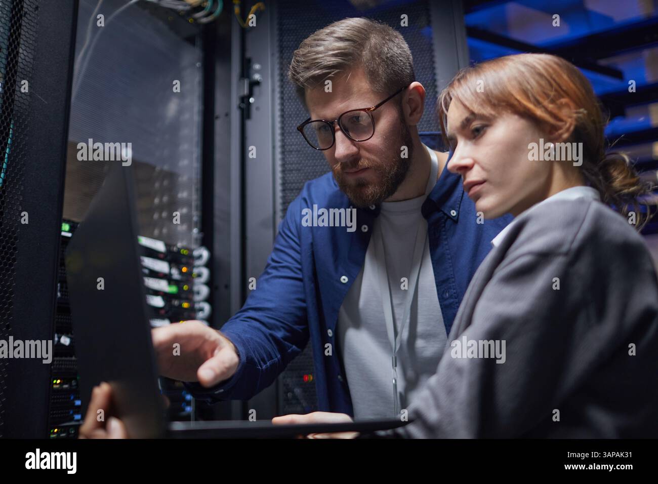 Multiracial team working on server maintenance in a data center. Man ...