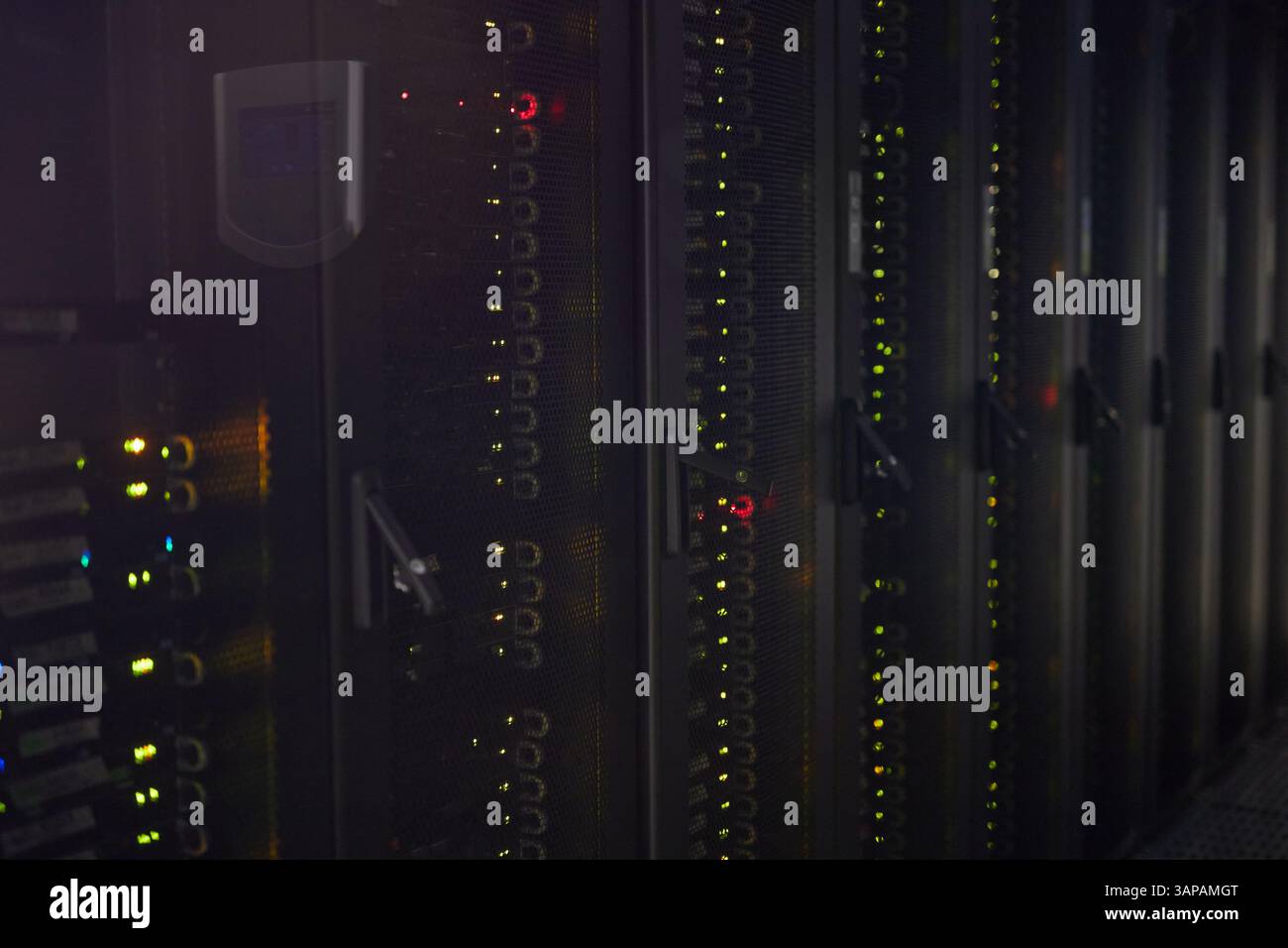 Multiple server racks with illuminated LED lights in data center providing large-scale data ...