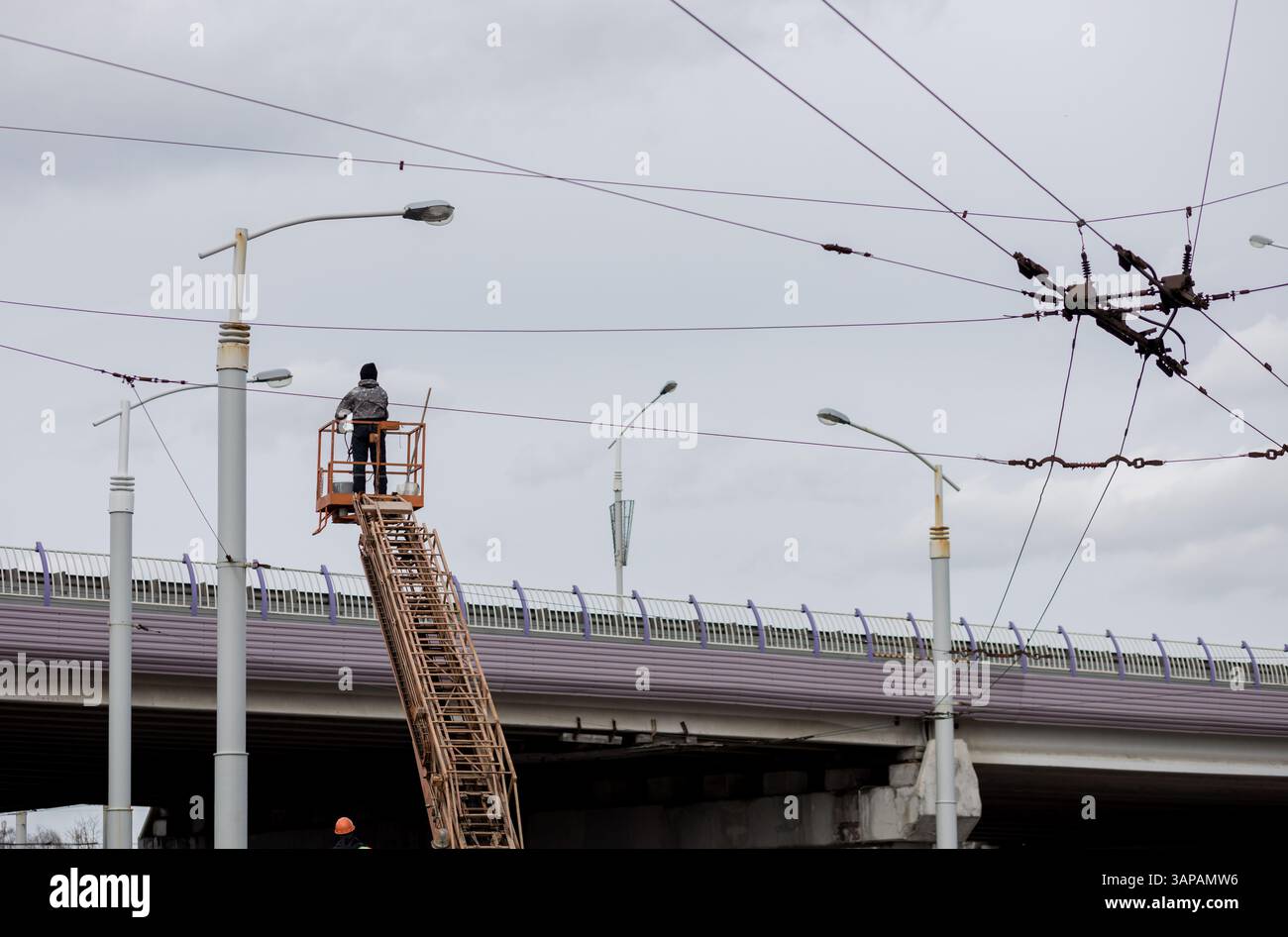 Electrician works on tower above city's electrical networks. Repair of ...