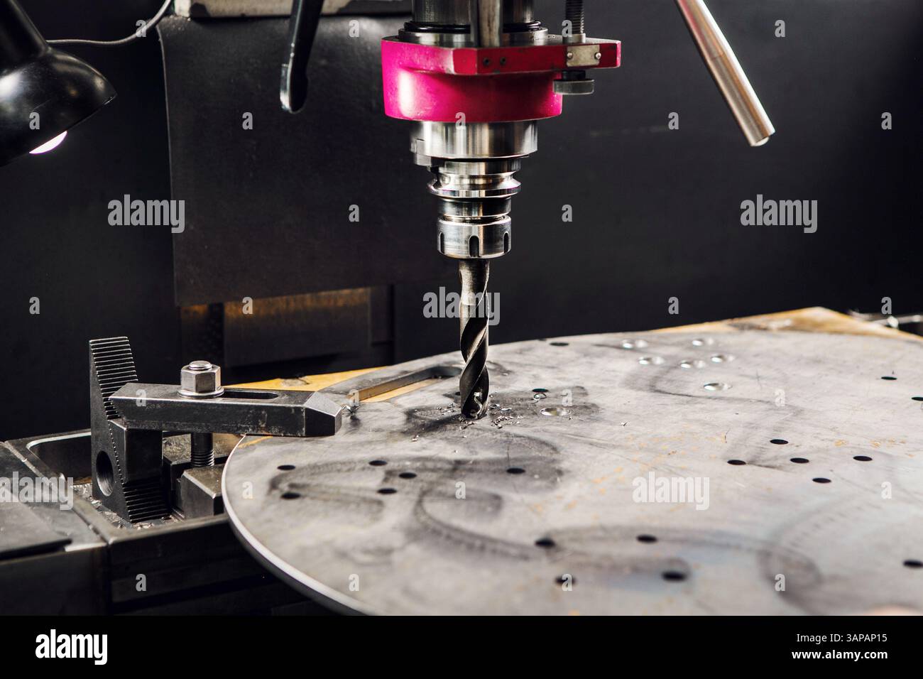 Vertical drill makes holes in metal part. Close-up of metal drilling ...