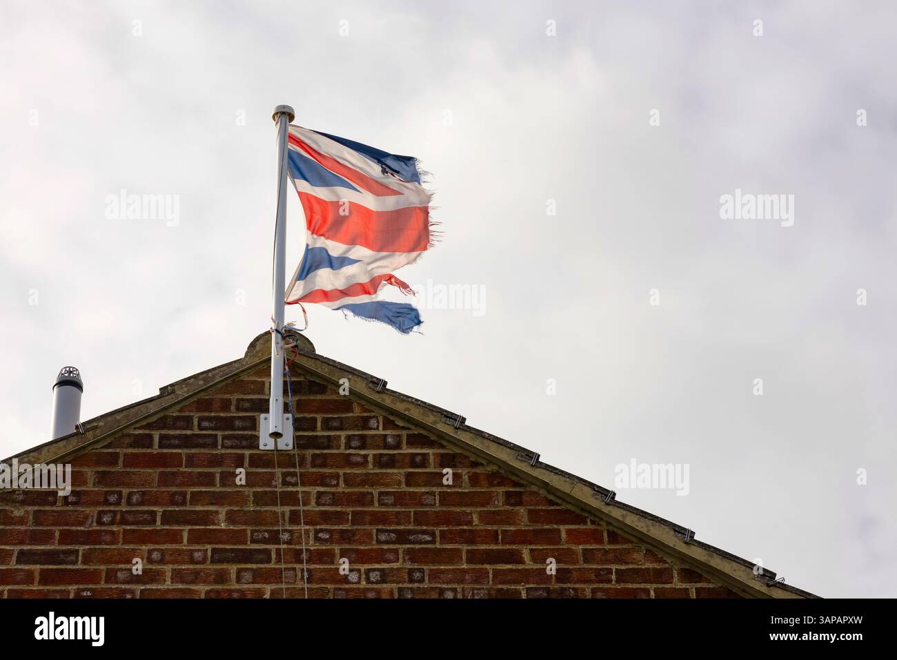 Ripped Union Jack Flag blowing in the wind Stock Photo - Alamy