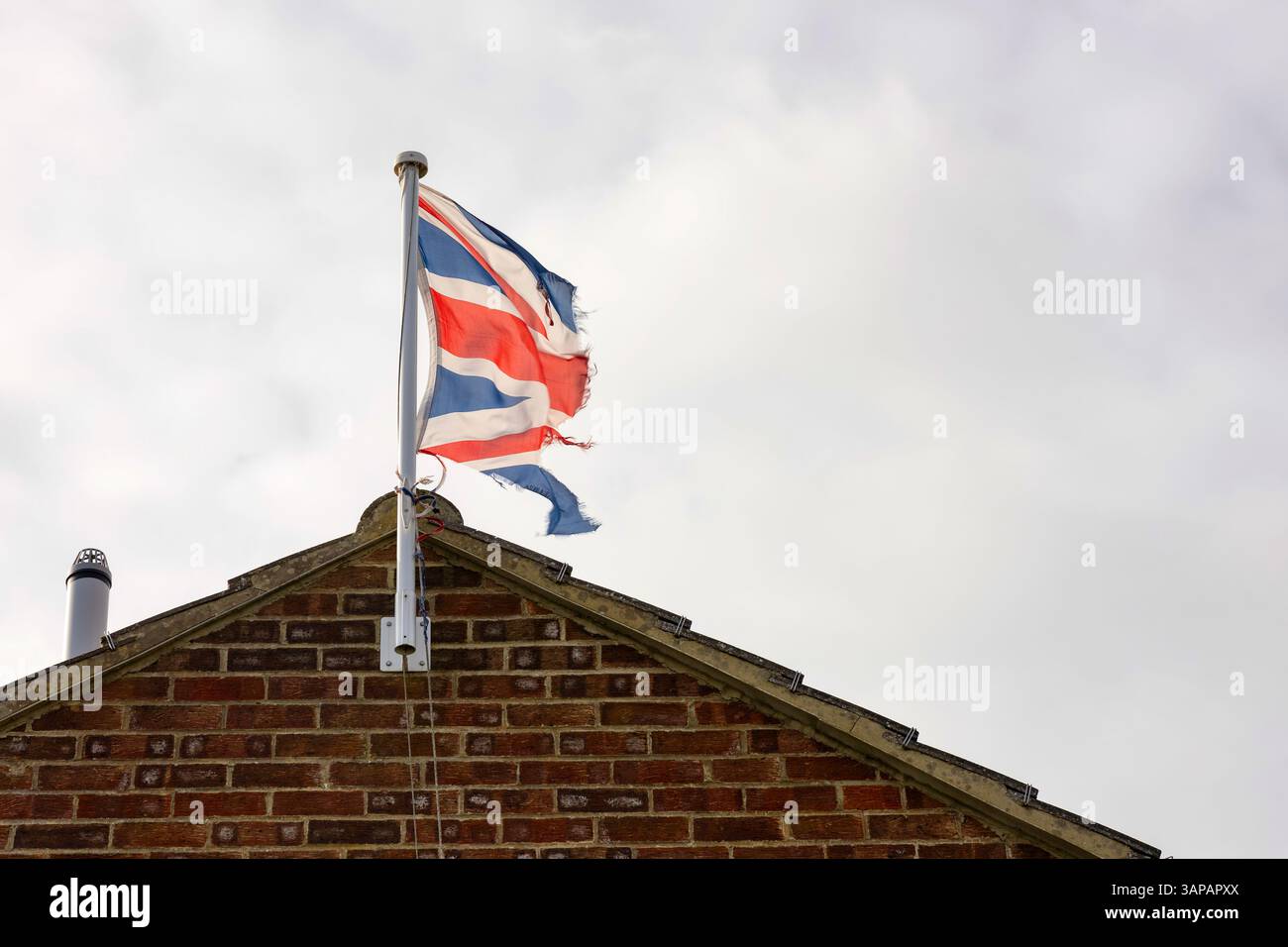 Ripped Union Jack Flag blowing in the wind Stock Photo - Alamy