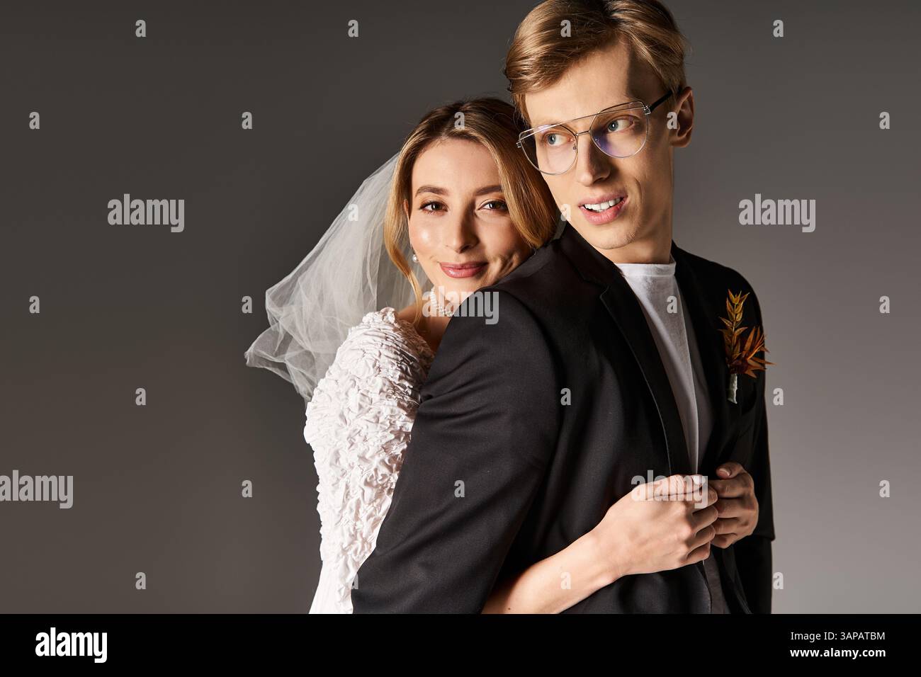 A radiant bride in a white dress embraces her groom as they celebrate ...
