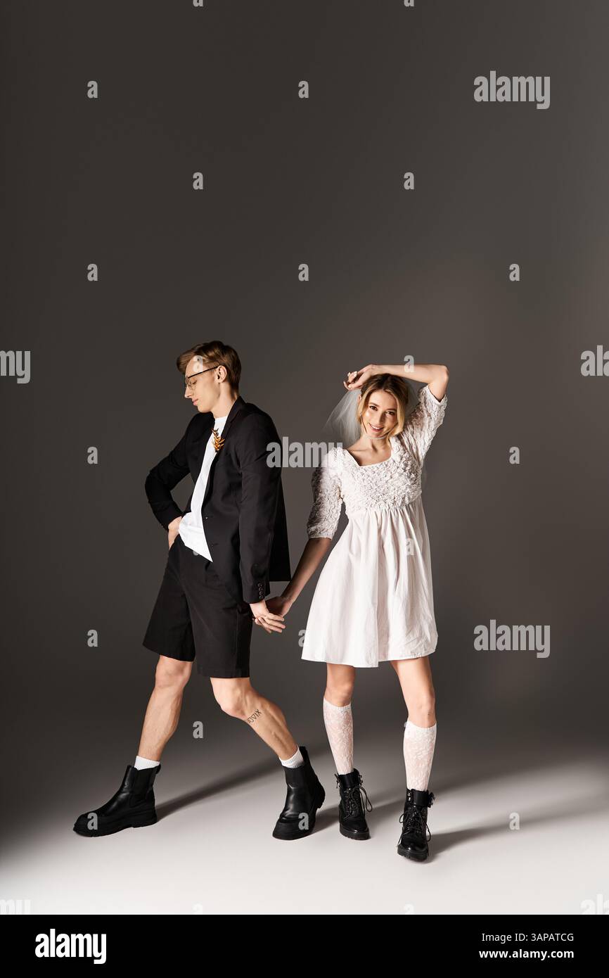 A joyful young couple showcases their unique wedding outfits, radiating ...