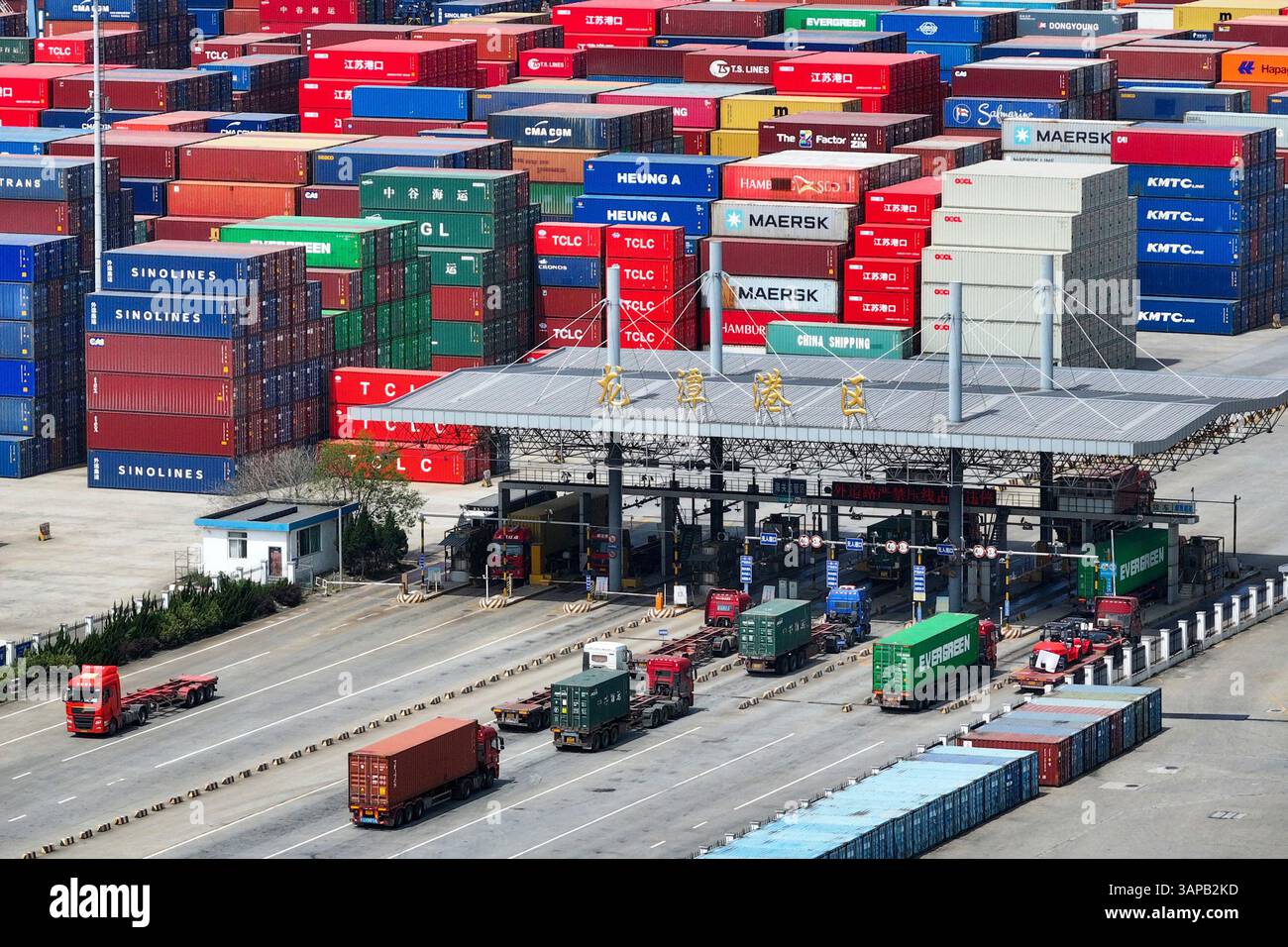 Trucks pass the gate to a container terminal in Nanjing in east China's ...