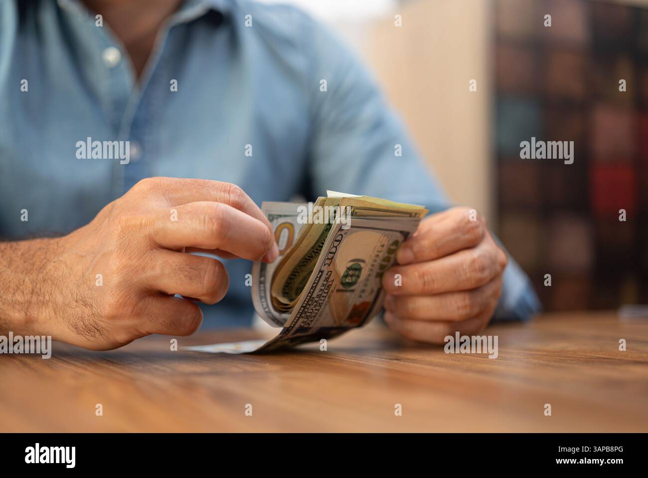 Male entrepreneur holds pack of dollar banknotes in hands carefully ...