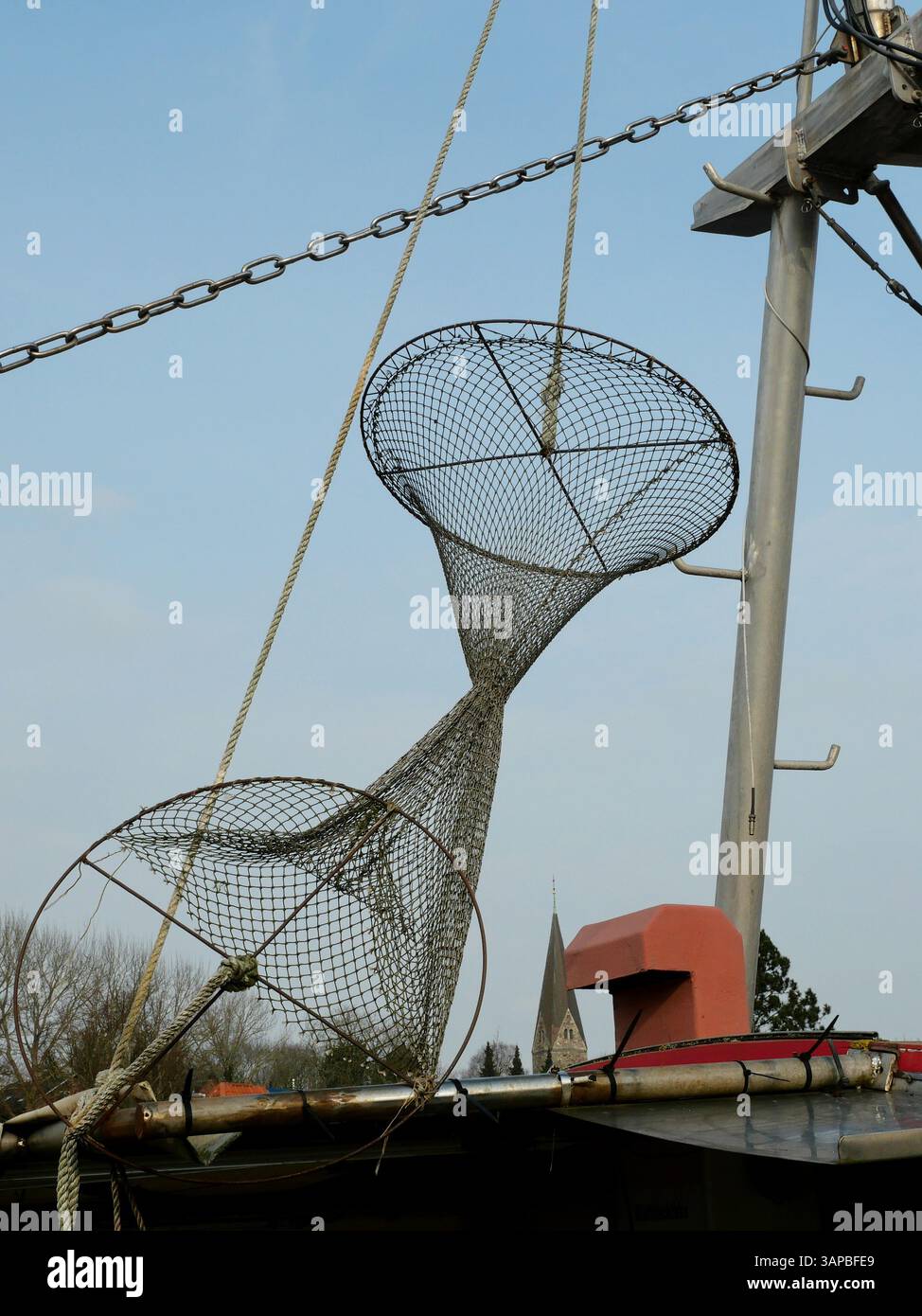 A fishing net hangs twisted like an hourglass on the mast of a fishing ...