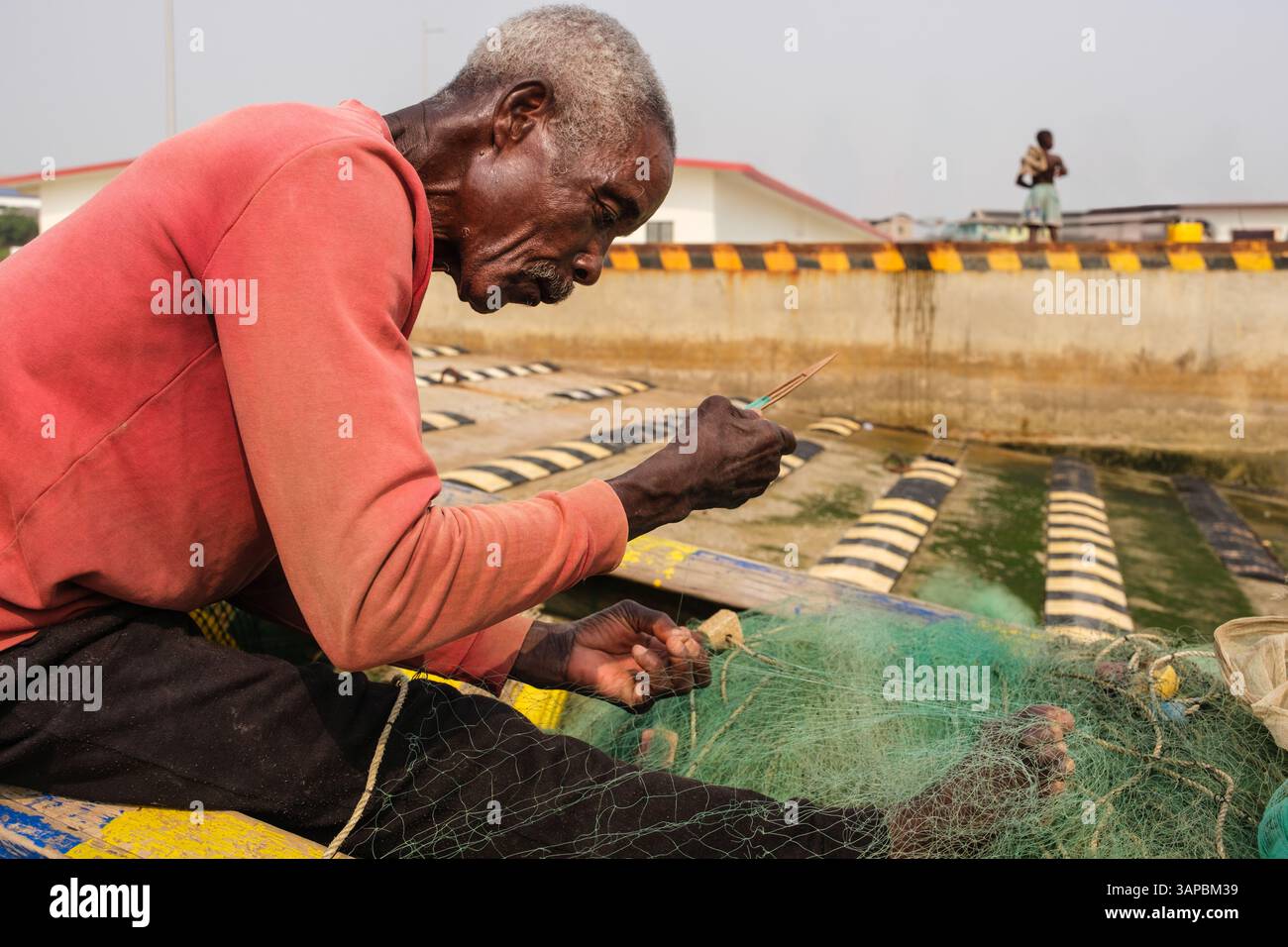 Accra, Ghana. Jamestown Fishing Harbor. Fisherman Mending his Nets ...