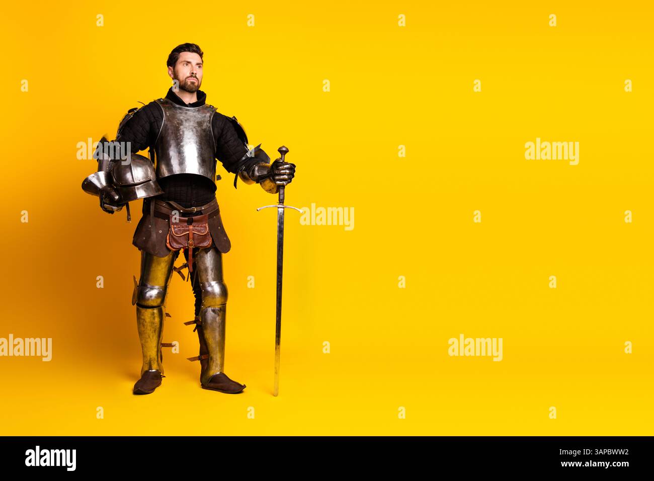 Man dressed as a medieval knight in full armor holding a sword and ...
