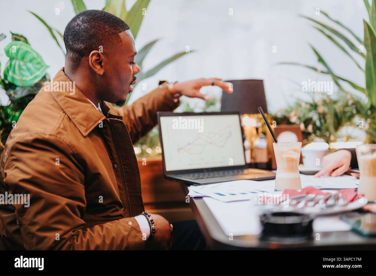 Two people collaborating in a modern setting, analyzing business charts ...