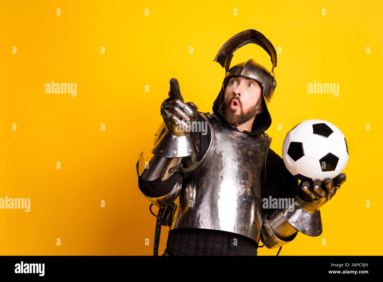 Medieval Knight in Armor Holding a Soccer Ball on Vibrant Yellow ...