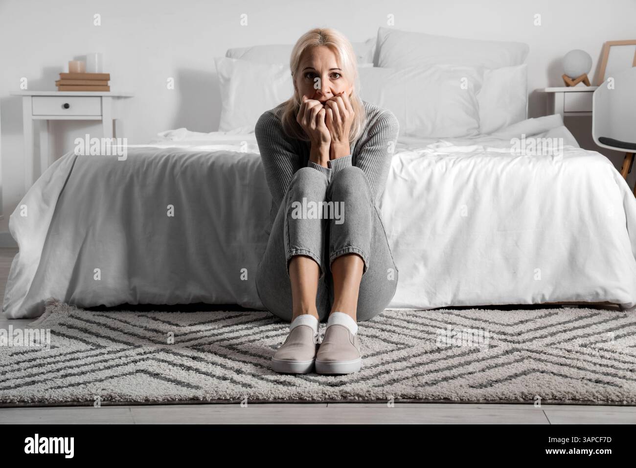 Mature woman having panic attack on floor in bedroom Stock Photo - Alamy