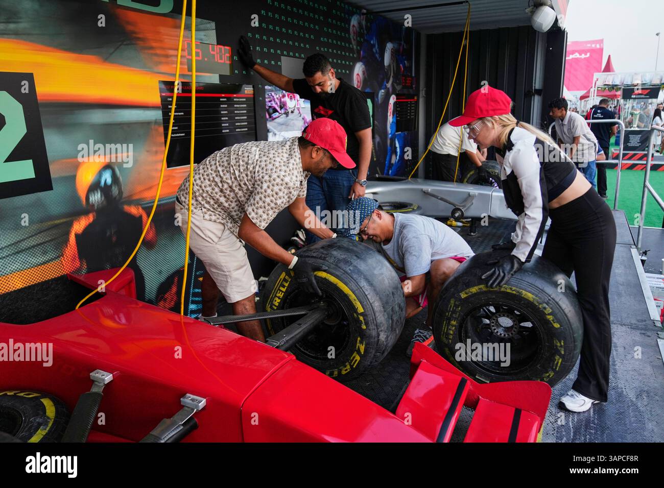 F1 fans take part in a pit stop contest at the Formula One Bahrain ...