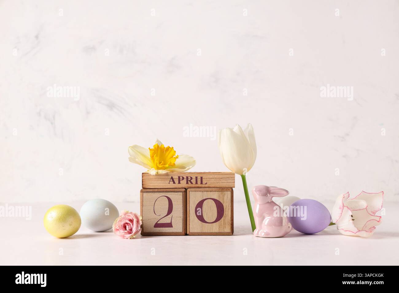 Wooden cube calendar with date 20 April, beautiful spring flowers ...